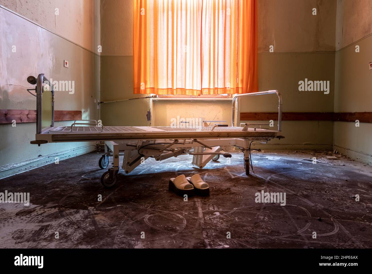 Very creepy and rotten hospital bed with ladies shoes in front of it ...