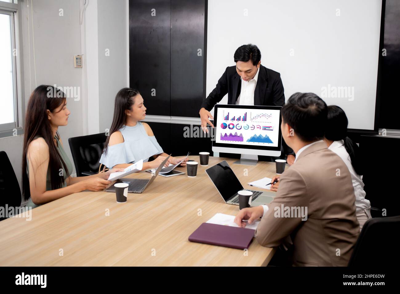Young businessman present graph report and statistics of profit with ...