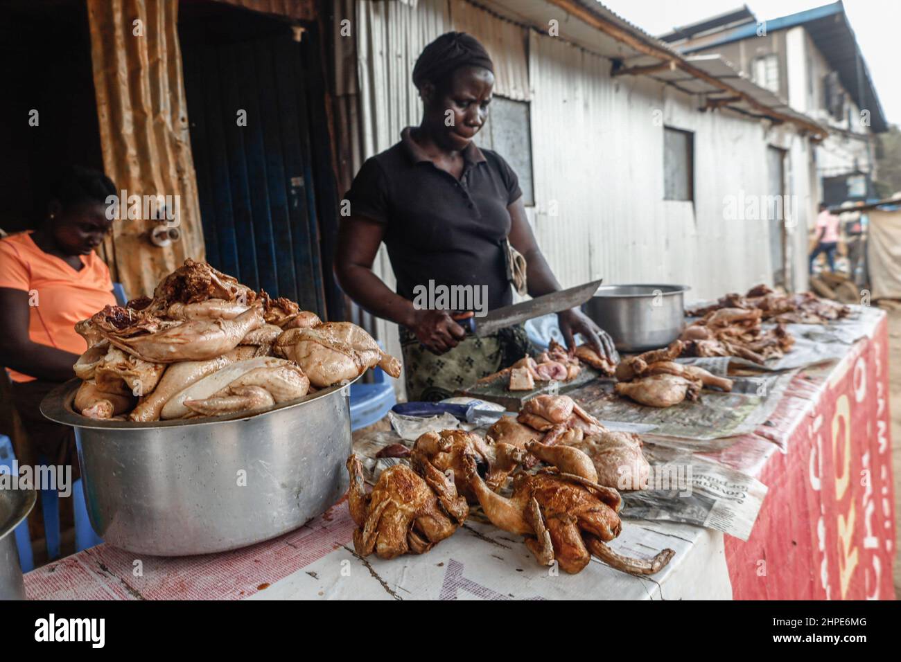 A woman prepares fried chicken for sell by the streets in Kibera Slums ...