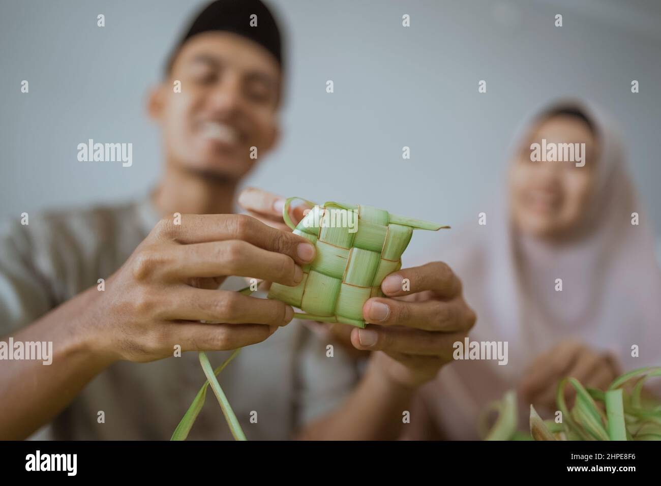 muslim couple asian making ketupat rice cake at home using palm leaf ...