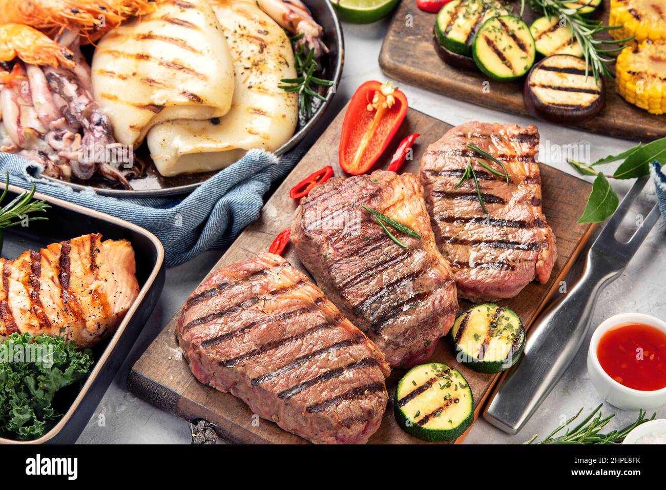 Grilled fish, seafood and meat assortment on light background. Homemade ...