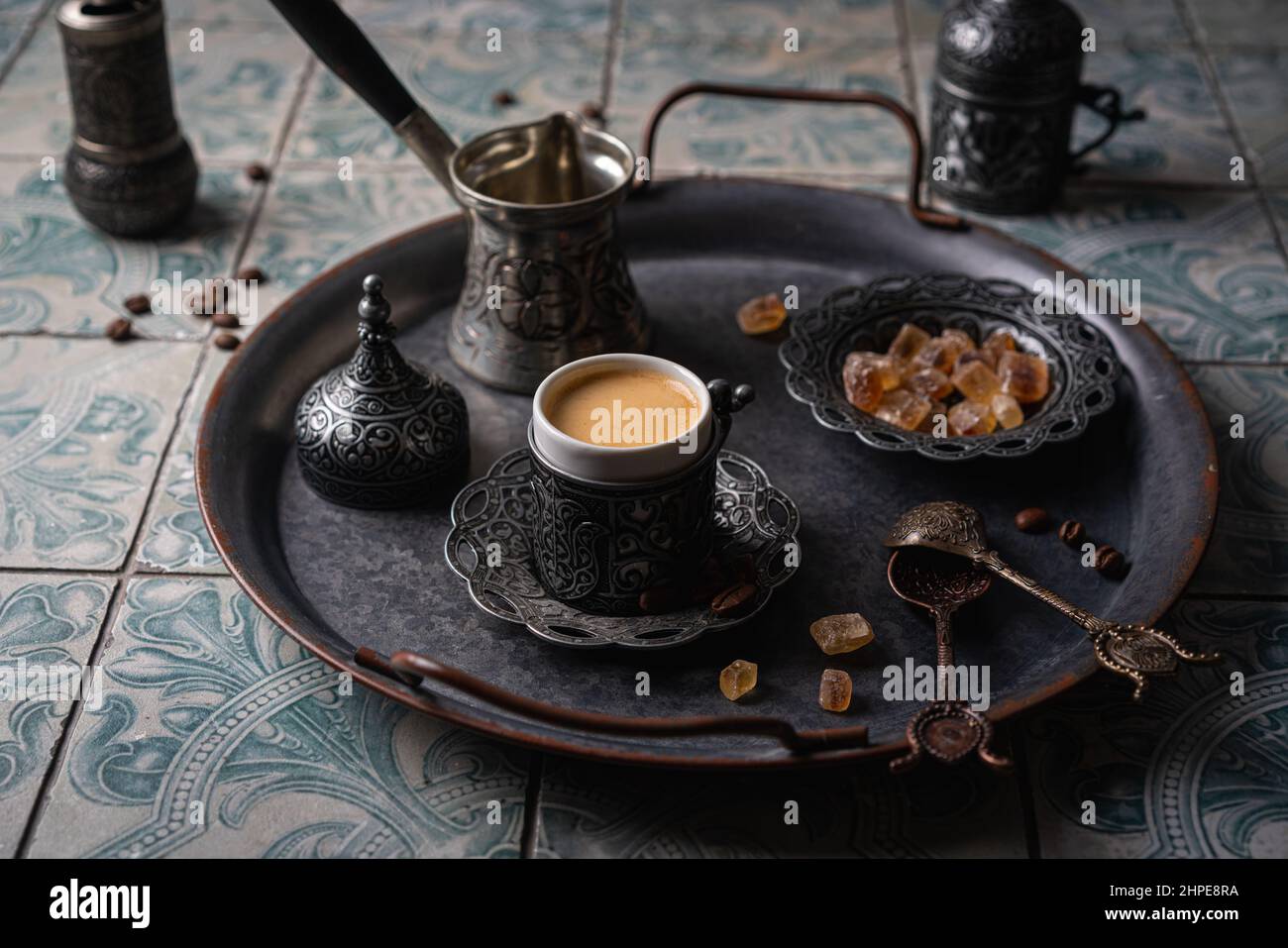 Coffee in metal Turkish traditional cup and coffee beans on tile ...