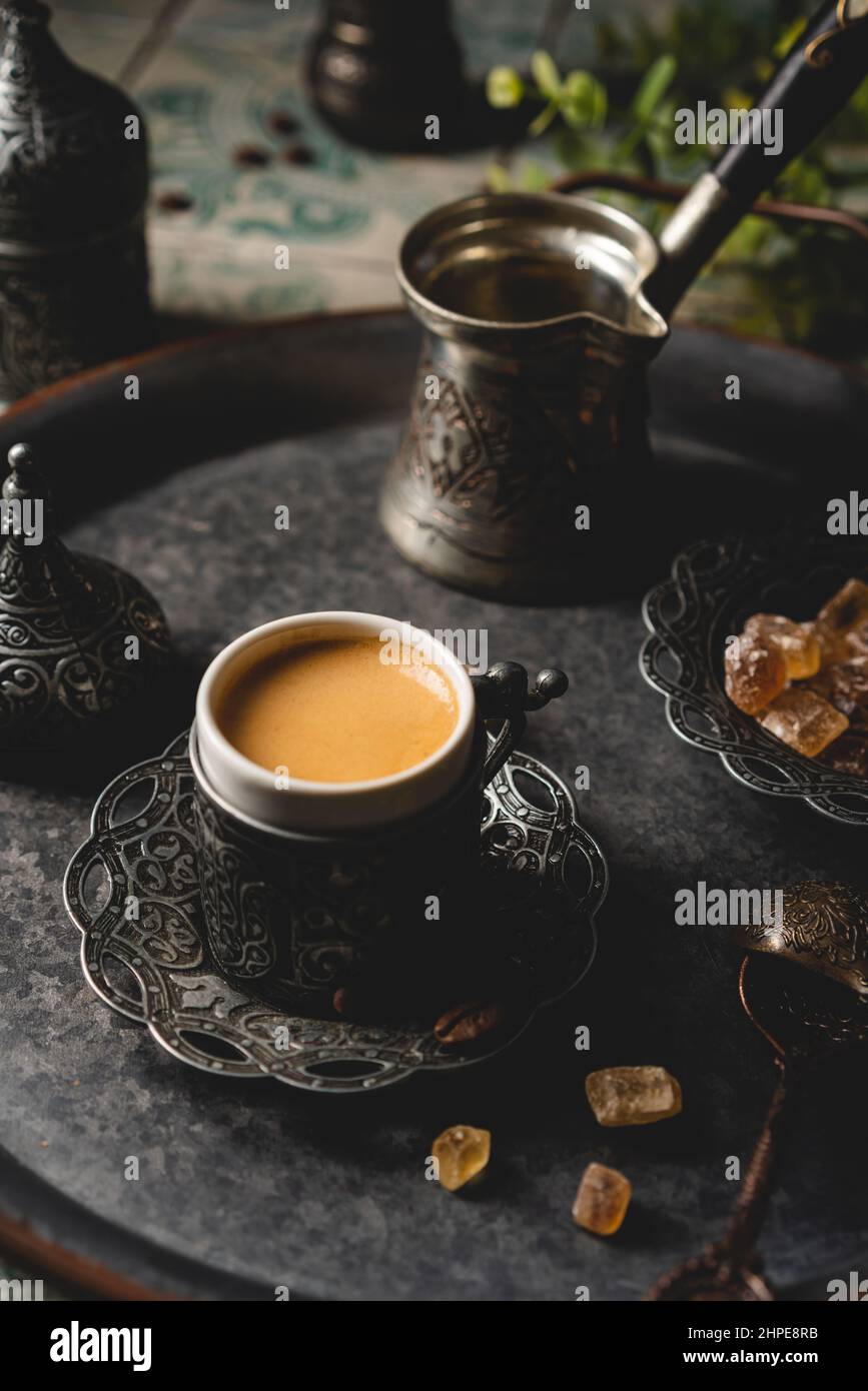 Coffee in metal Turkish traditional cup and coffee beans on tile ...