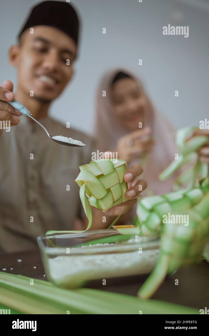 muslim couple asian making ketupat rice cake at home using palm leaf ...