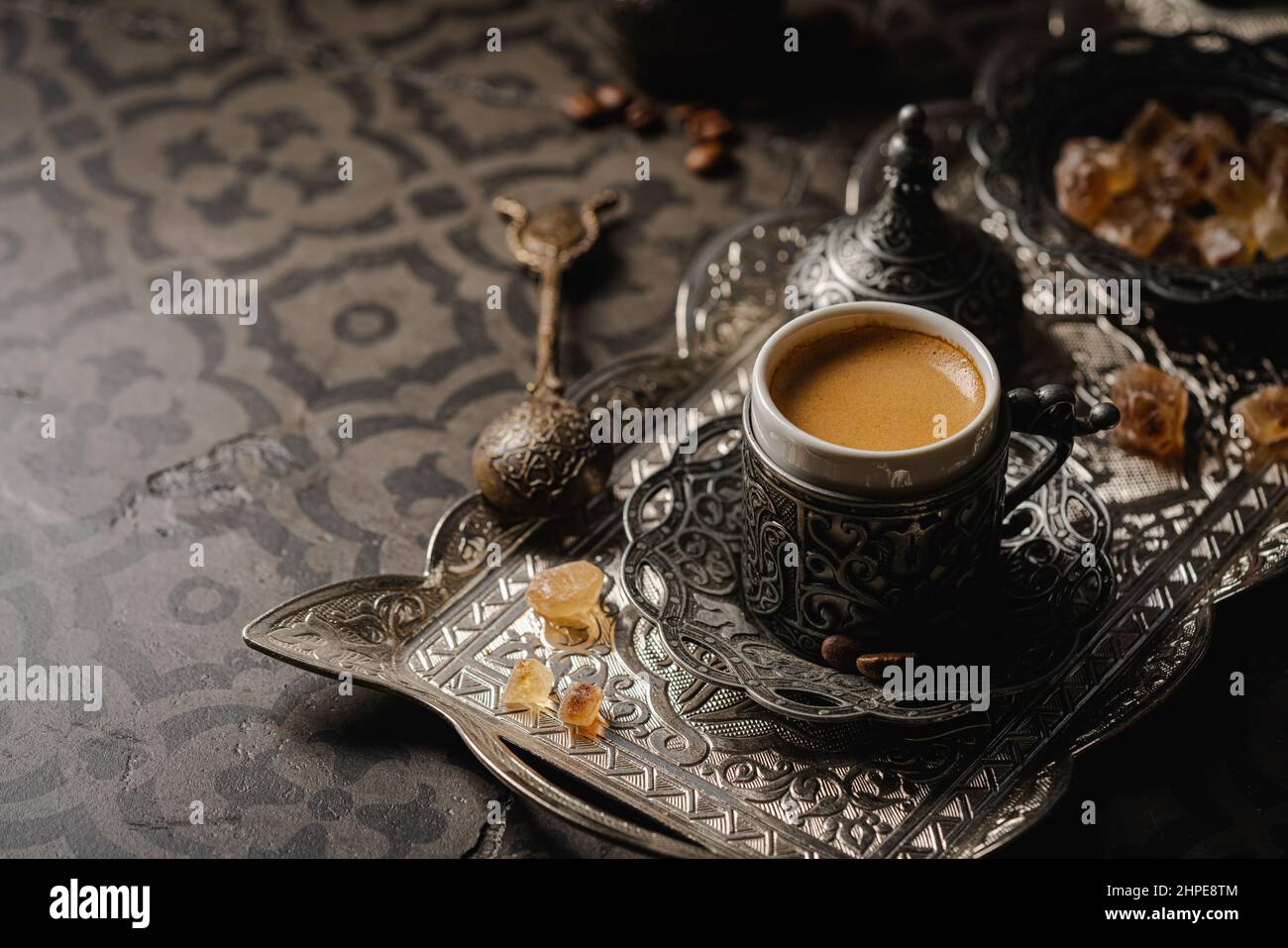 Coffee in metal Turkish traditional cup and coffee beans on dark tile ...