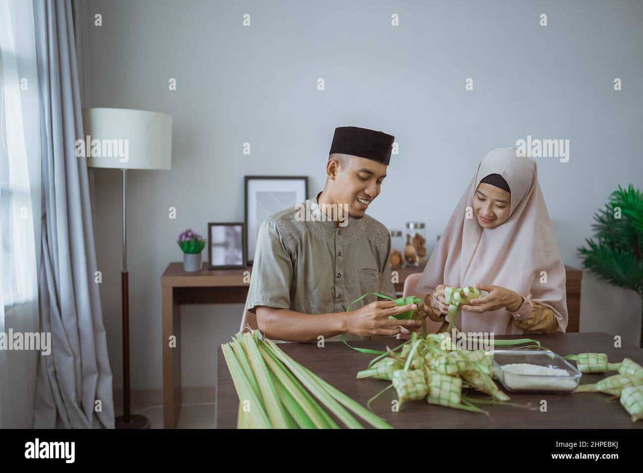 muslim couple asian making ketupat rice cake at home using palm leaf ...