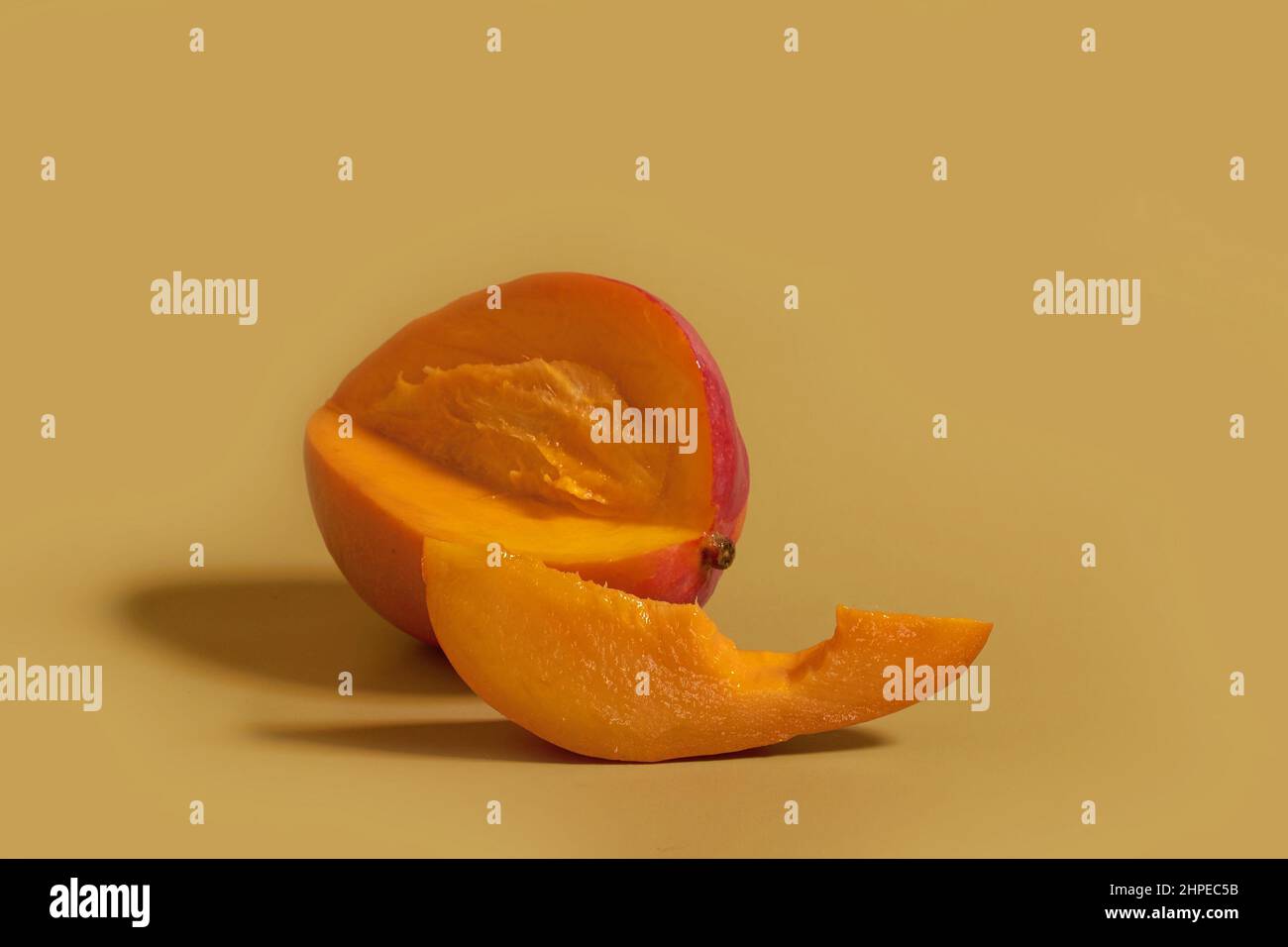 Ripe sliced mango and a bitten slice on a colored background Stock ...