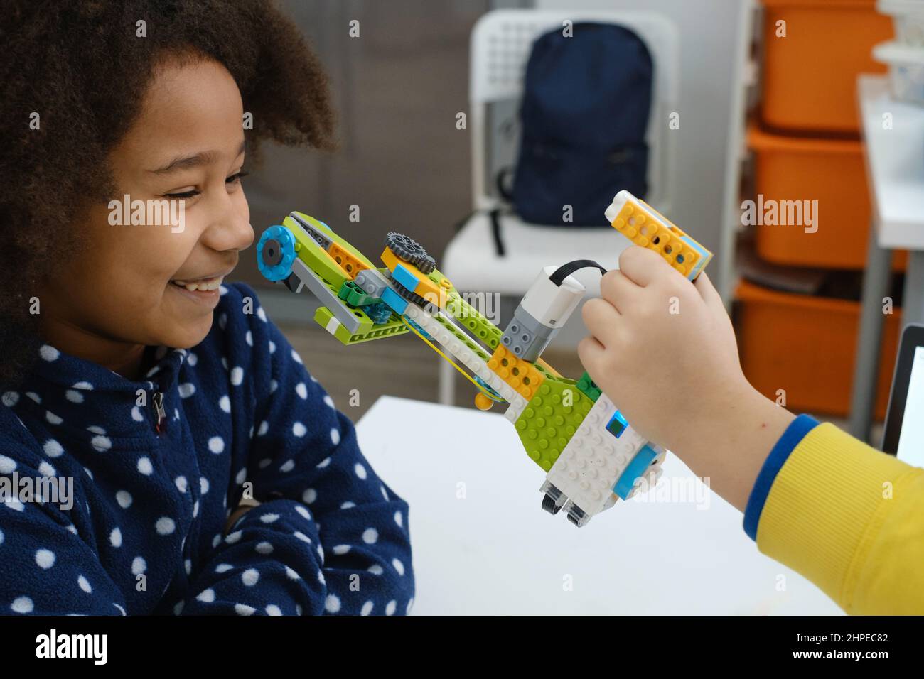 Coding Class, school girl constructing robot arm mechanism. multiethnic ...