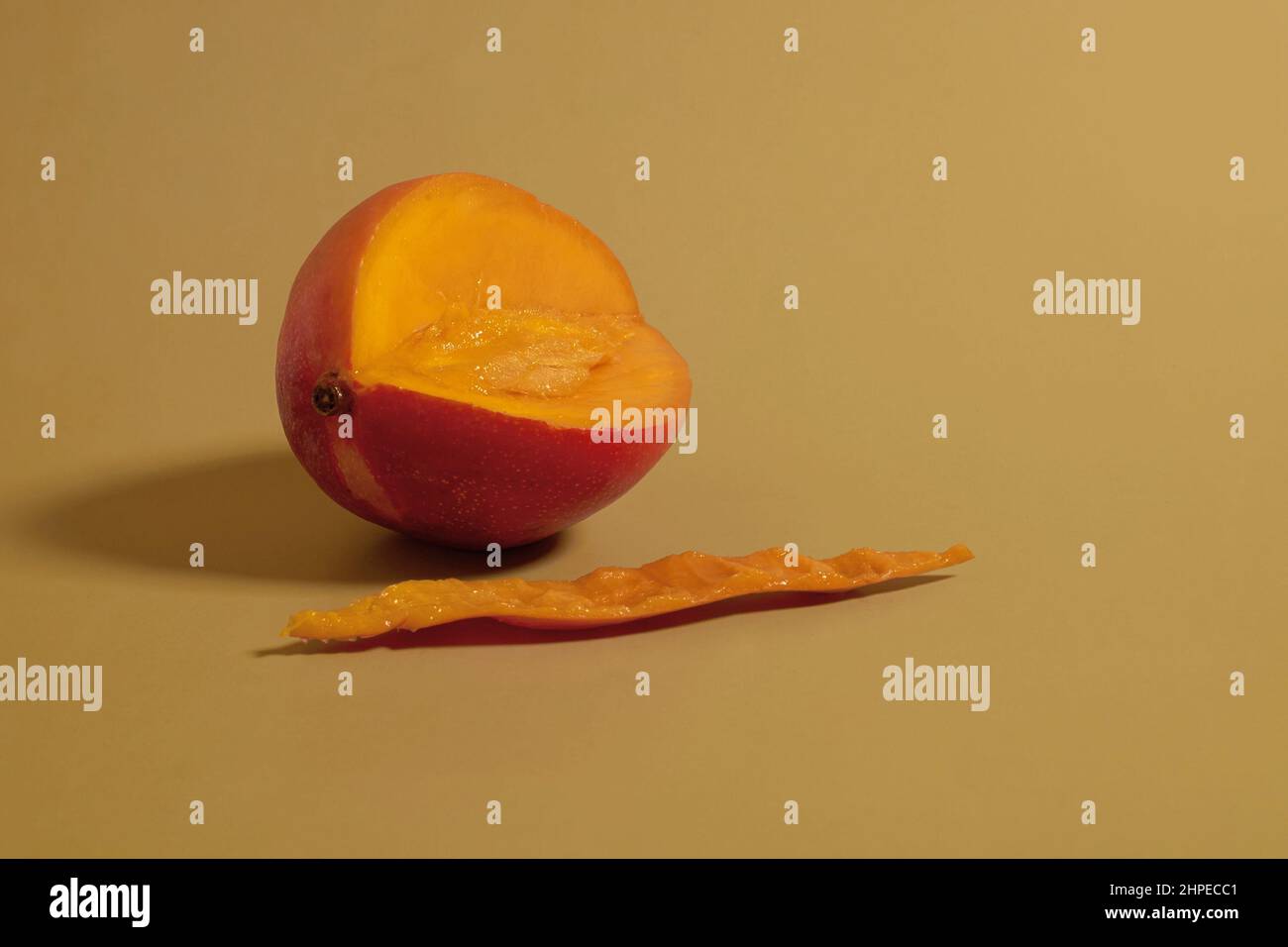 Ripe sliced mango and eaten mango peel on a colored background Stock ...