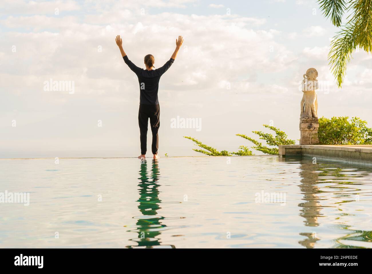 A man standing at the edge of infinity pool Stock Photo - Alamy