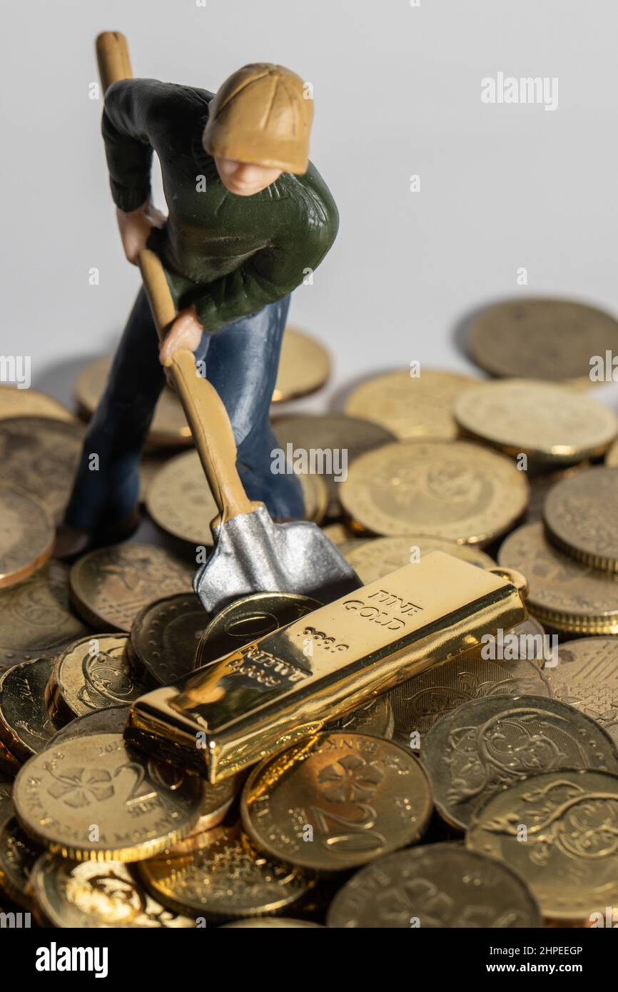 Industrial Engineering worker digging with gold bar and coin as ...
