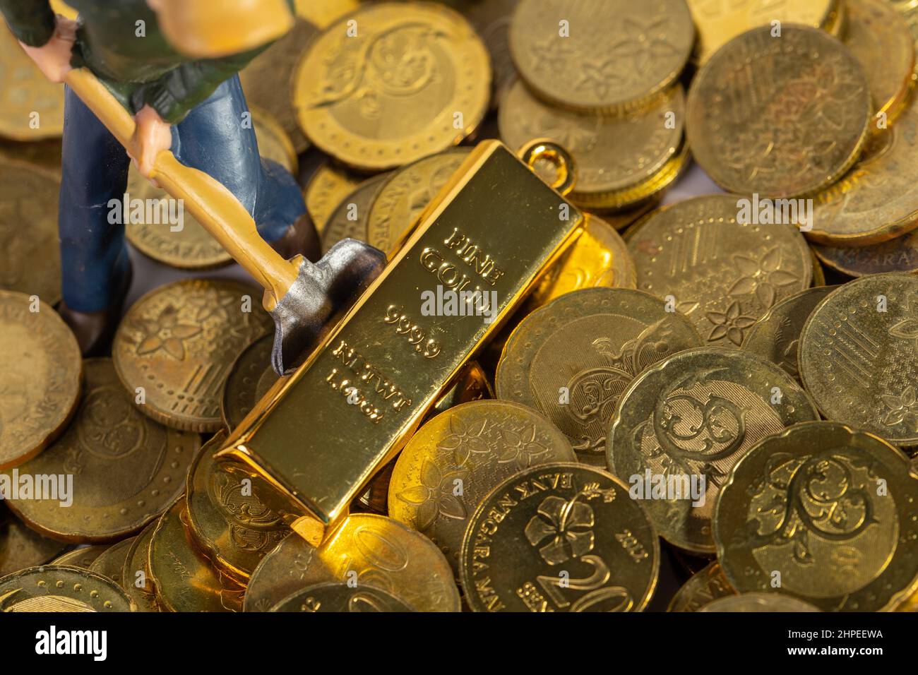 Industrial Engineering worker digging with gold bar and coin as ...