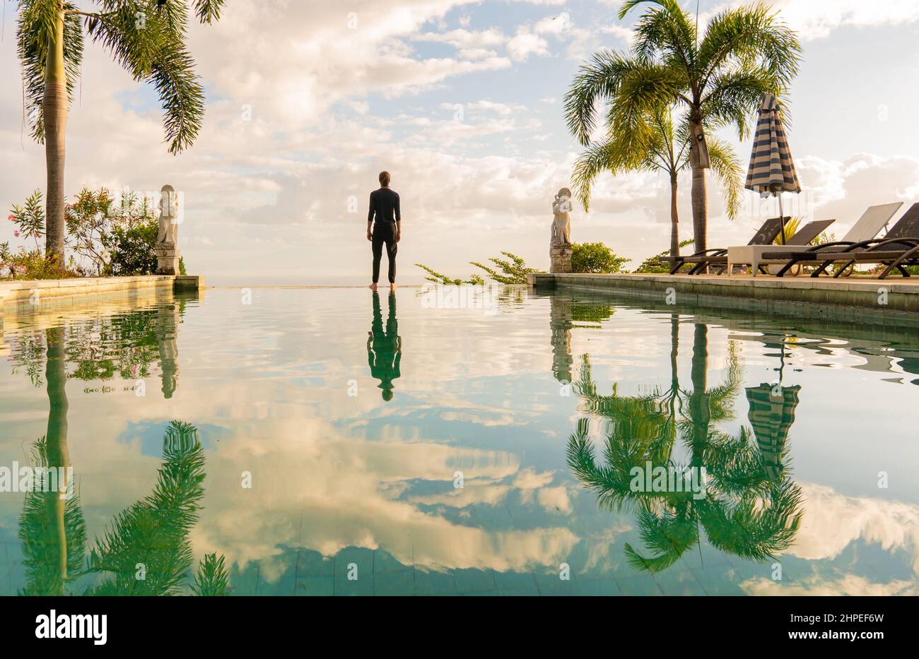 A man standing at the edge of infinity pool Stock Photo - Alamy