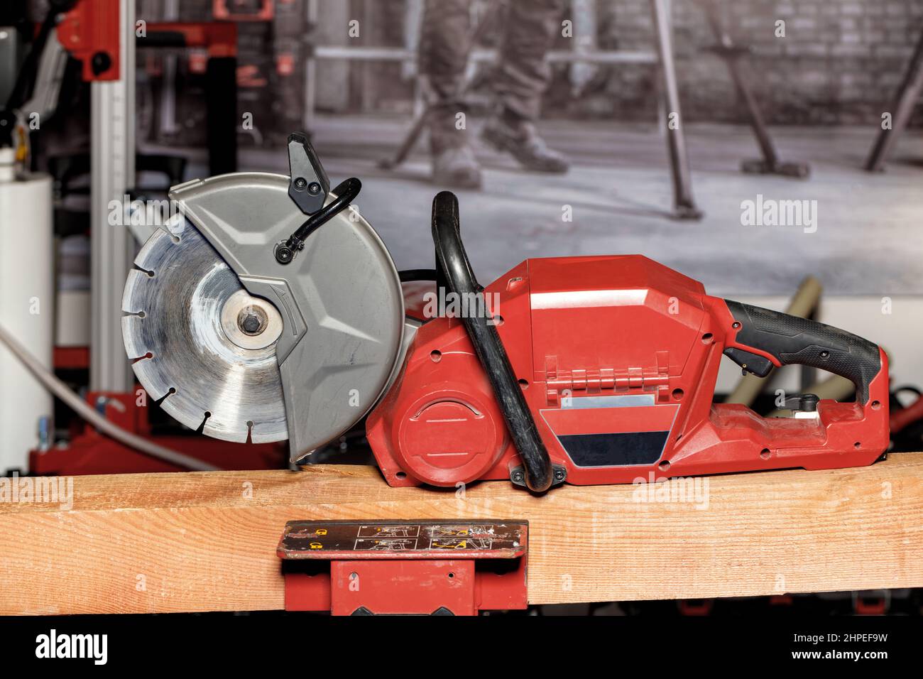 Worn portable red electric cutter with a diamond cutting wheel on a ...