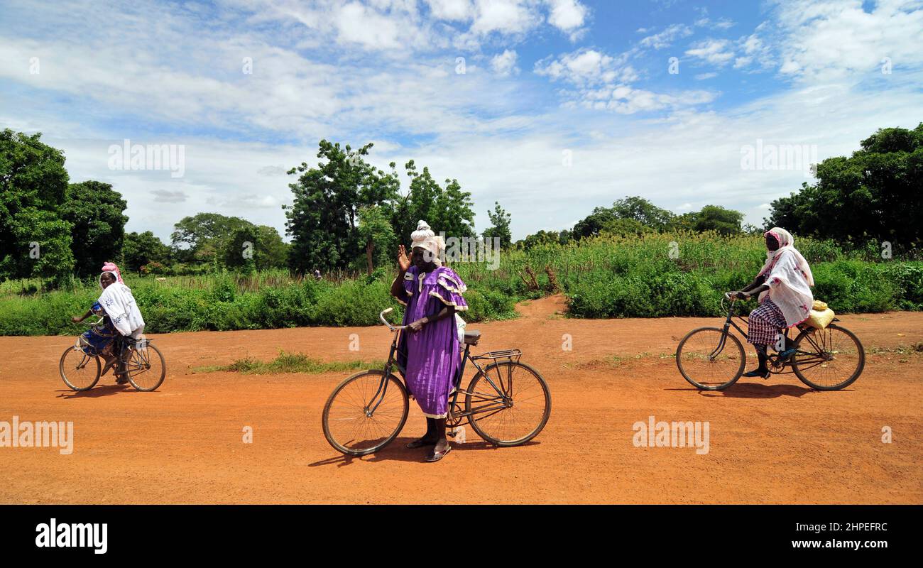 Burkinabe women riding their bicycles in rural areas of central Burkina ...