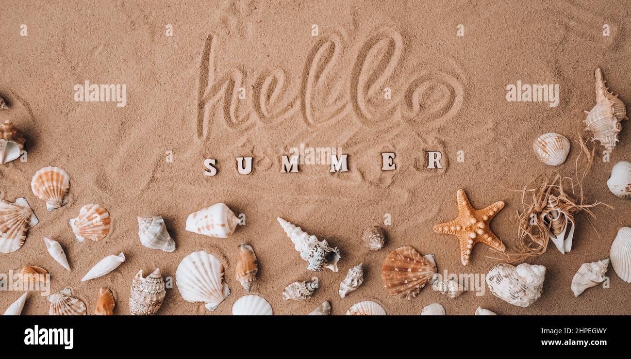 Composition with text HELLO SUMMER seashells, pebbles, mockup on sand ...