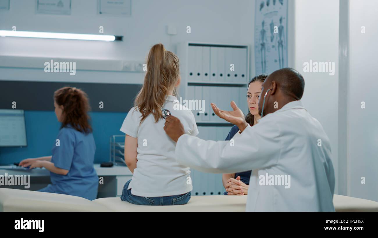 Health specialist using stethoscope on child to measure pulse and ...