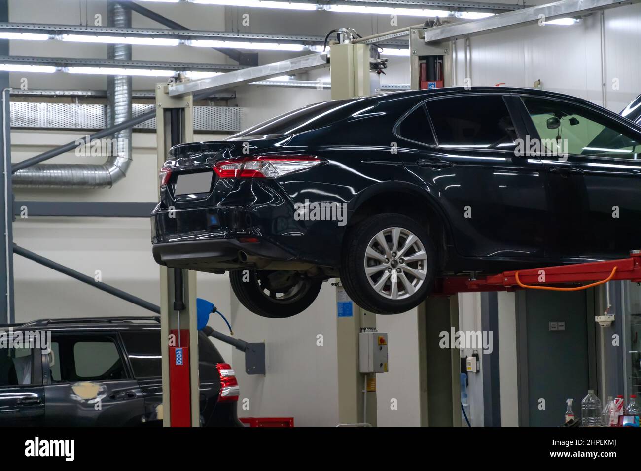 Dark blue car is lifted on a car lift in a service station Stock Photo ...