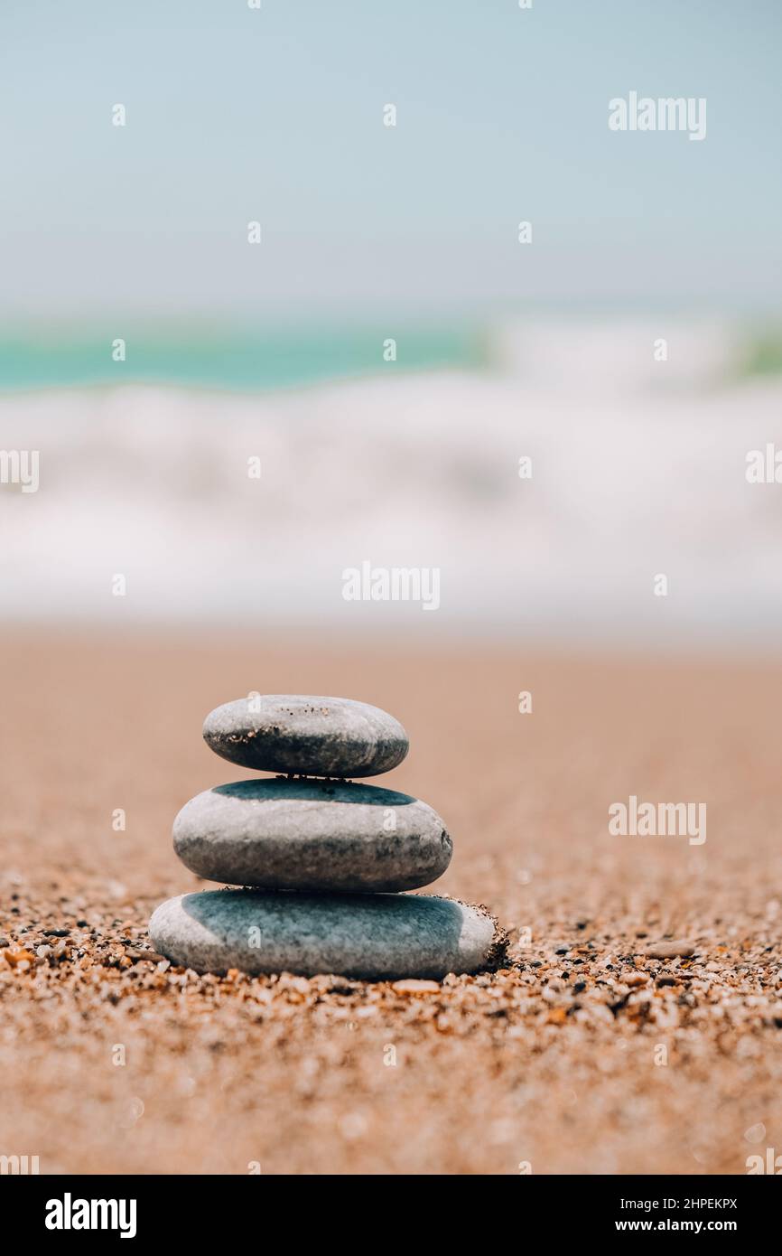 Rock balancing on ocean beach. Pyramid of pebbles on sandy shore ...