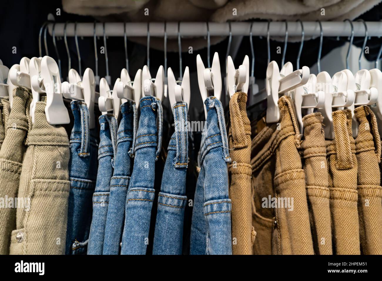 fashionable jeans are hanging on a hanger in the store Stock Photo - Alamy