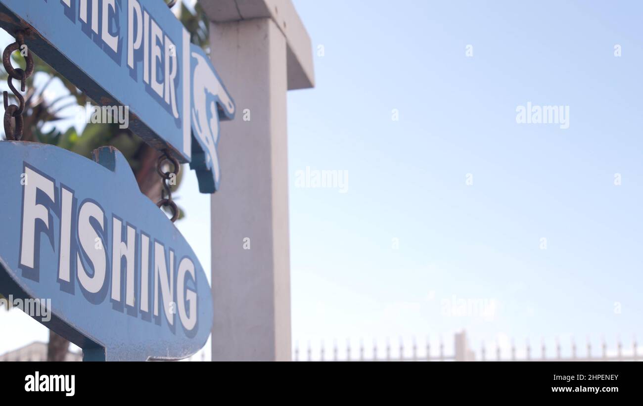 Fishing on pier wooden blue sign, California ocean beach, USA. Coast ...