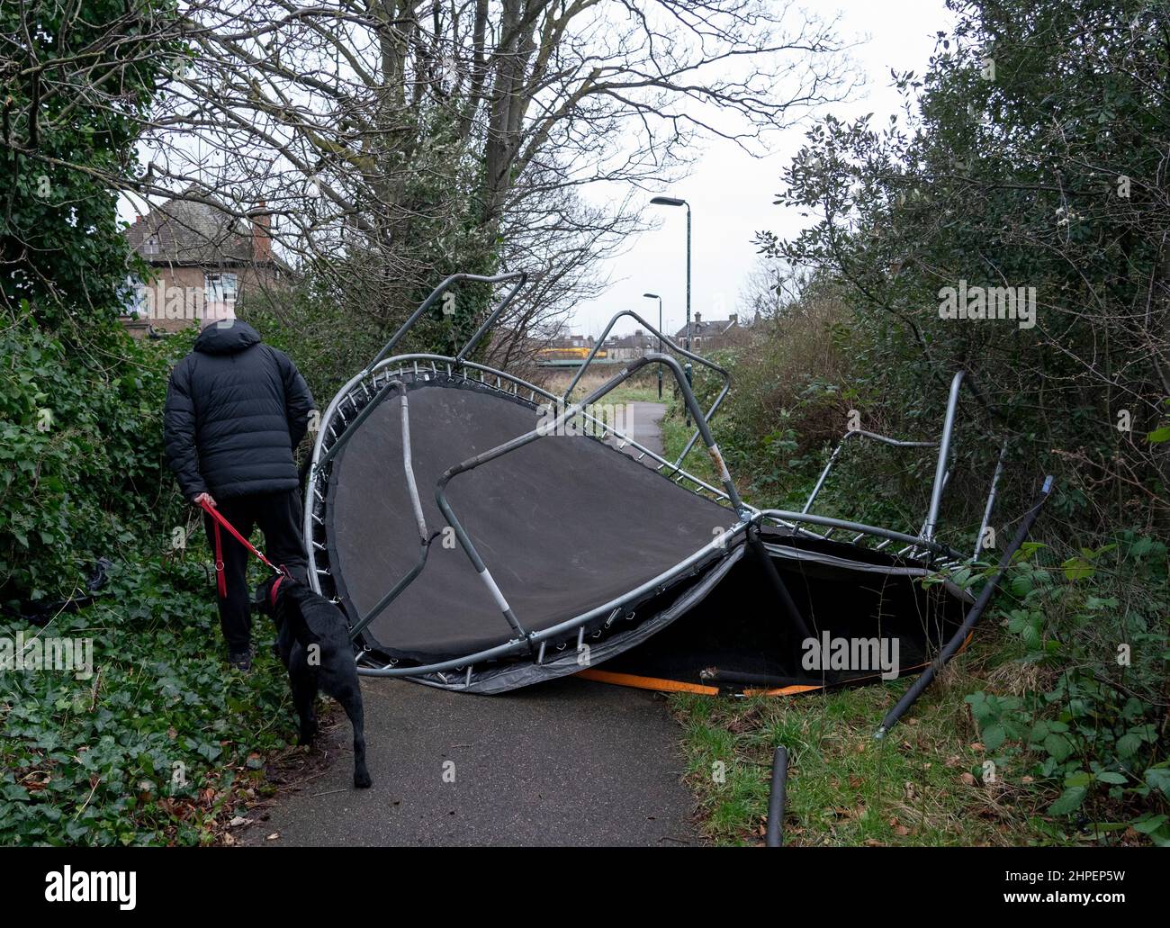 A trampoline blown from a back garden by Storm Eunice blocks a public ...