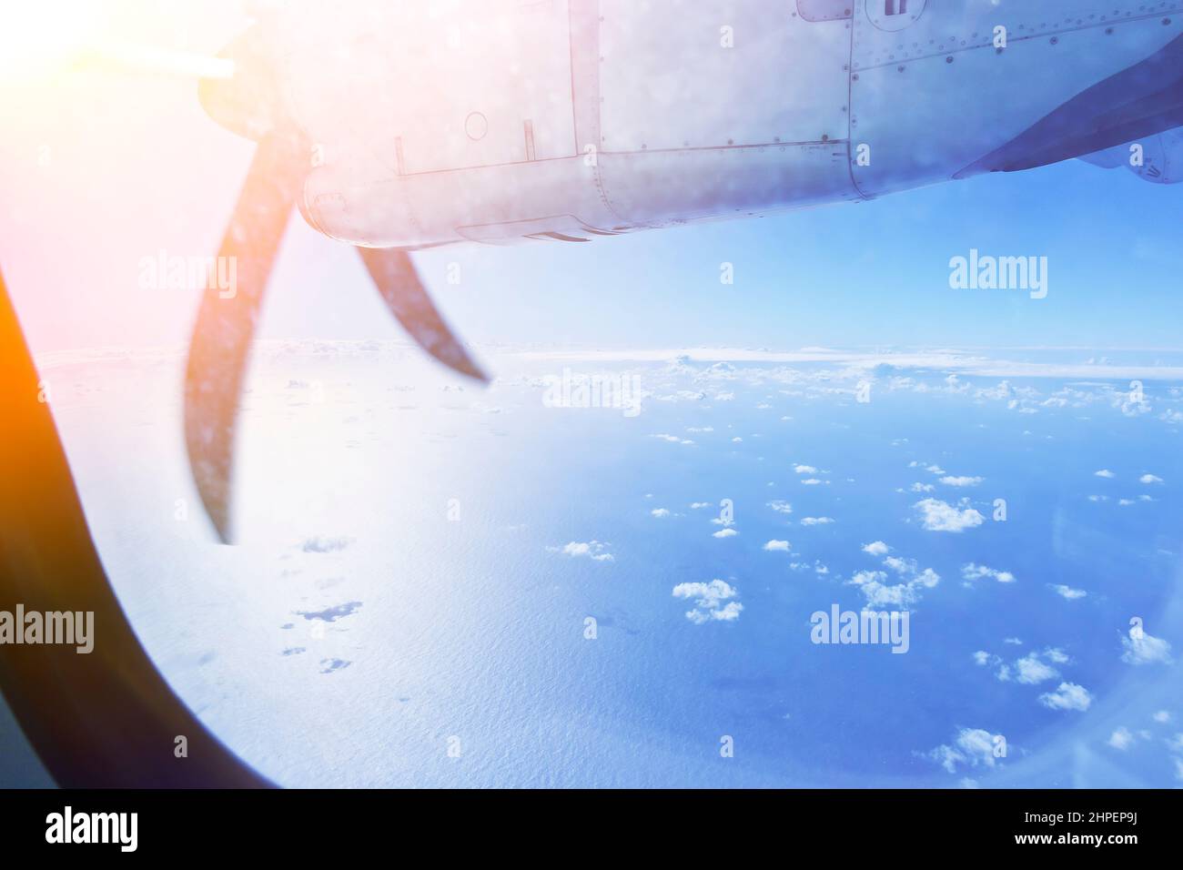 Wing and propeller of a small airplane during flight above ocean and a ...