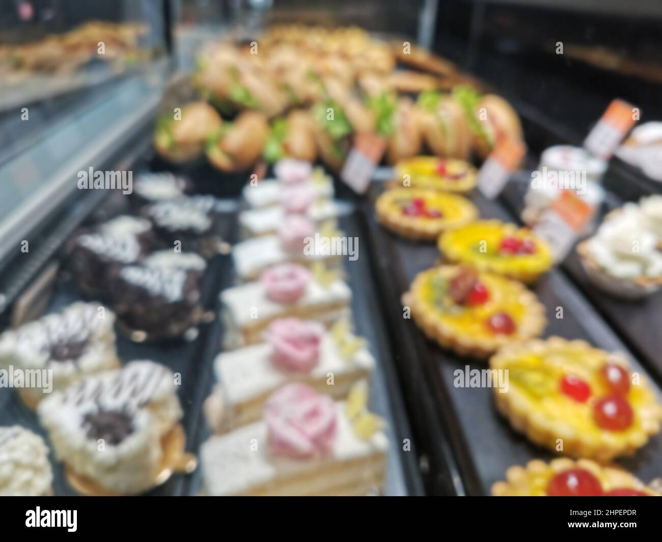 Blured view of the cake shelves in the store, a lot of cakes in the ...