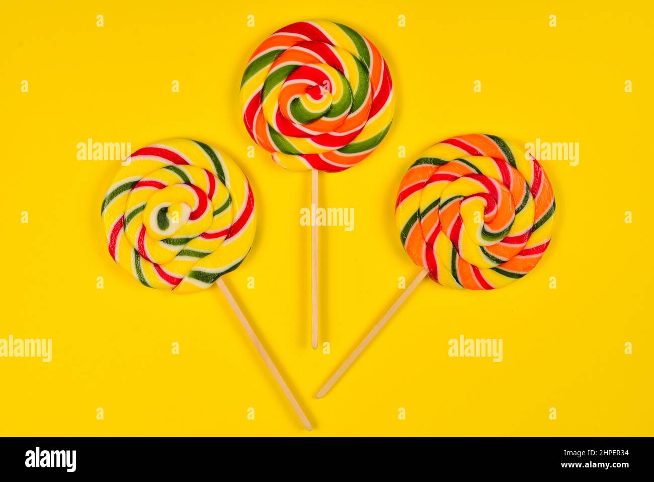Colorful candy on a yellow background. Lollipop. Top view. Copy space ...