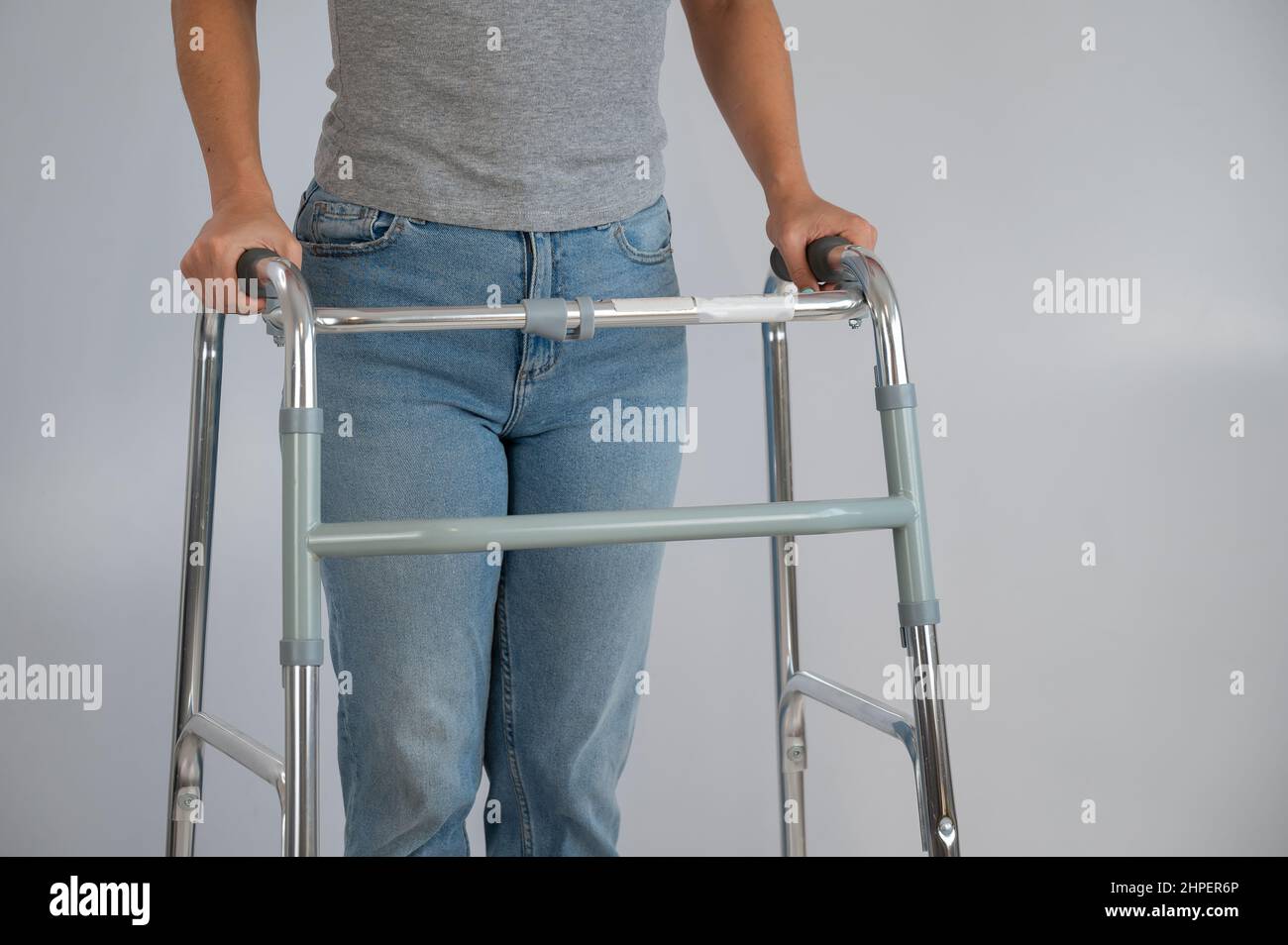A woman is walking with a walker on a white background Stock Photo - Alamy
