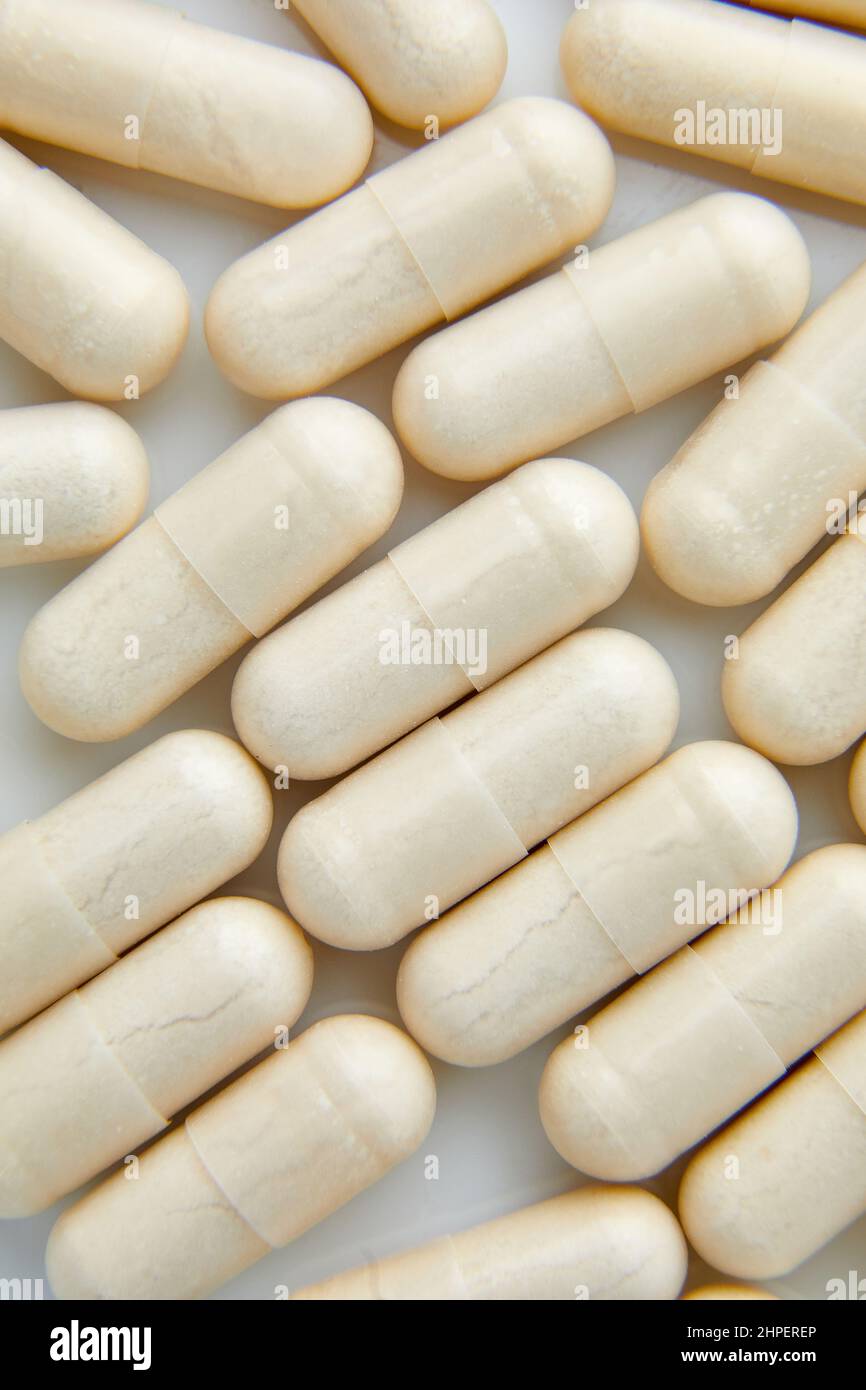 Flat lay macro White beige capsule pills, tablets, top view, close up ...