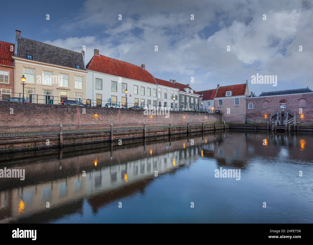 Row of monumental mansions reflected in a harbor at twilight, the ...