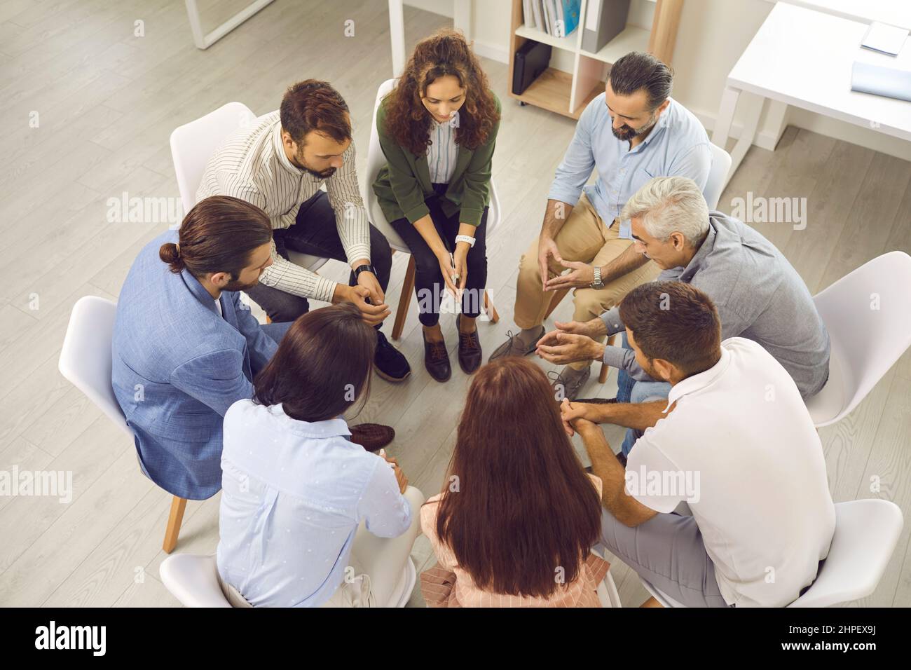View from above of people sitting in circle and talking during group ...