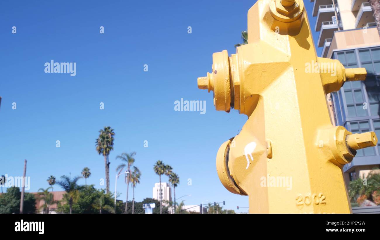 Yellow fire hydrant extinguisher on pavement of San Diego city street ...
