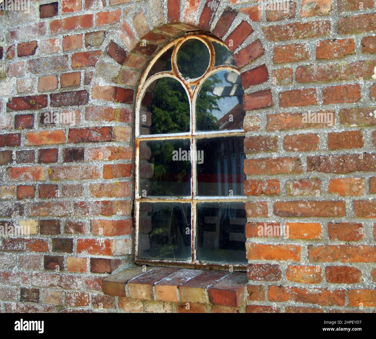 The window of a stable near an old mill. It has an arch and glass ...