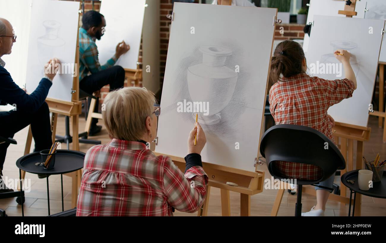 Senior woman attending art class lesson to develop new skills, learning ...