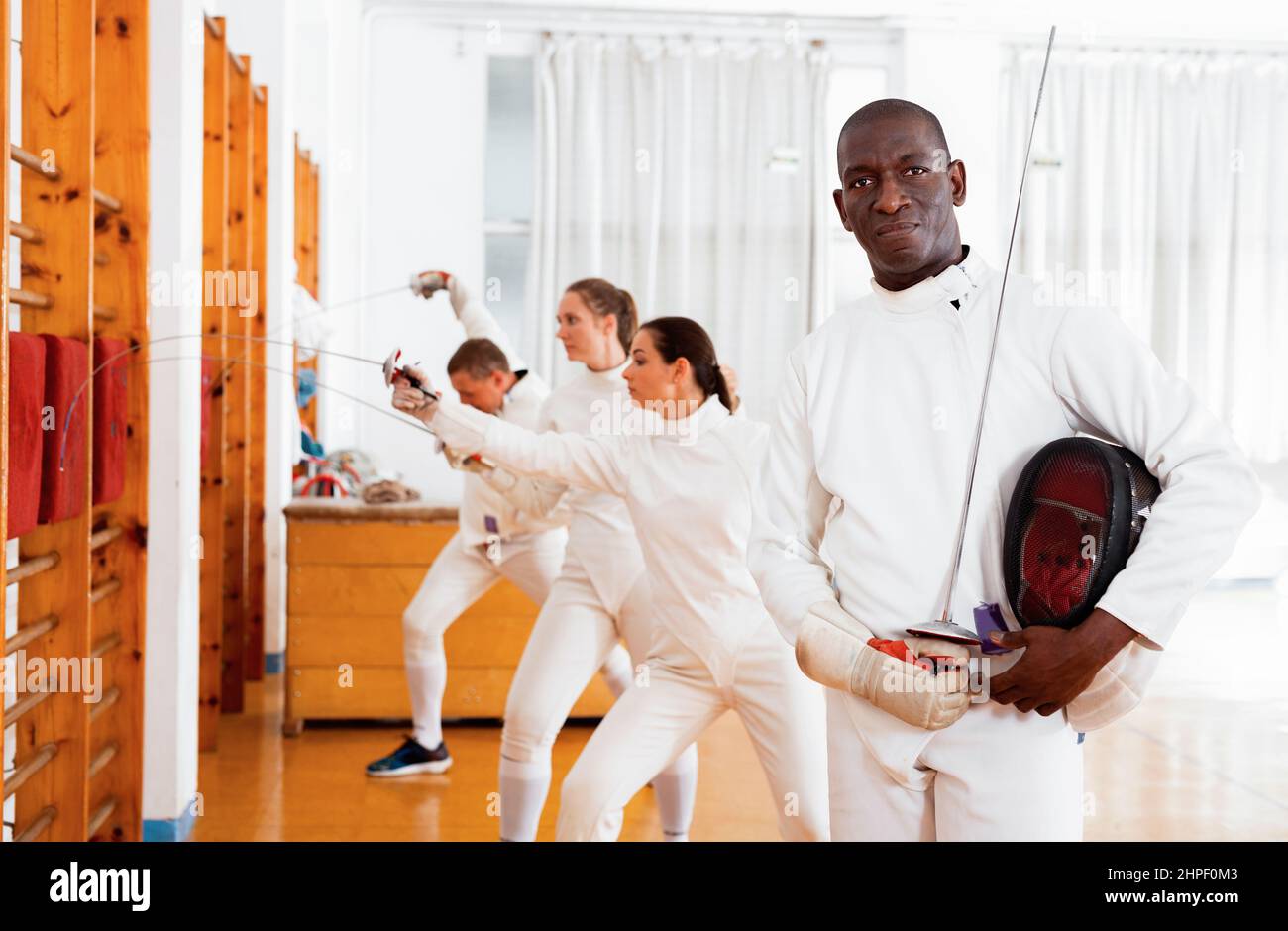 Active african american male fencer in uniform standing with mask and ...