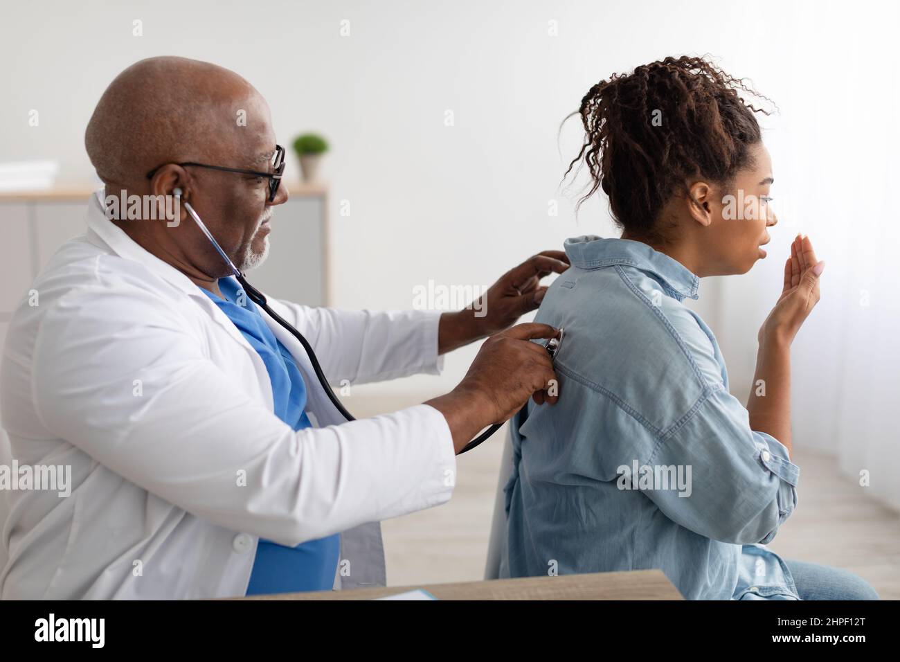 Black male doctor checking breath of female patient Stock Photo - Alamy