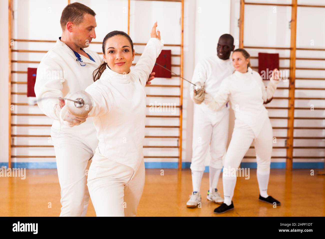 Female practicing movements with trainer at fencing workout Stock Photo ...