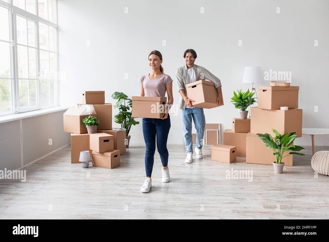 Cheerful millennial caucasian man and lady in casual, packing ...