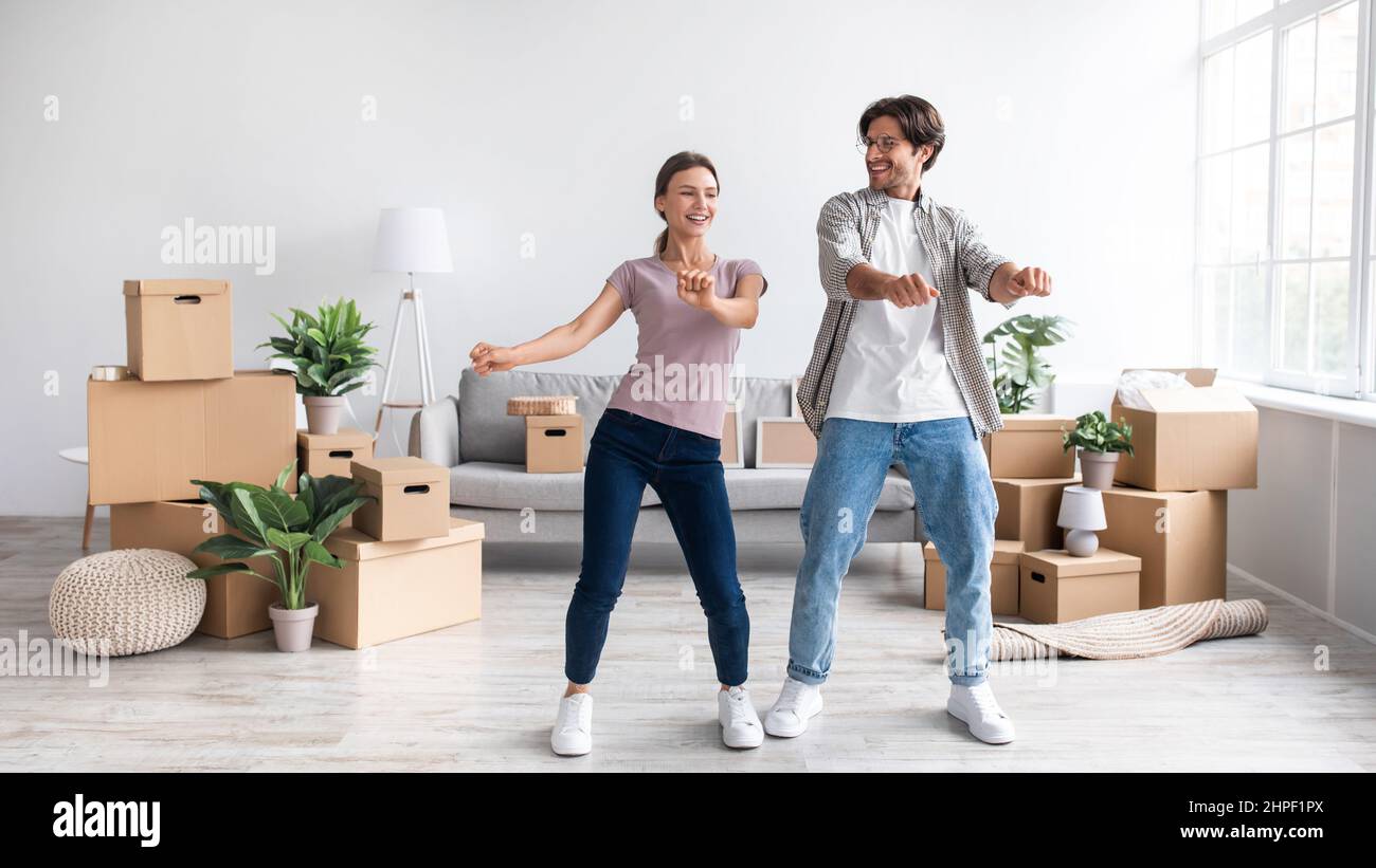 Glad millennial european lady and guy dance, have fun, packing ...