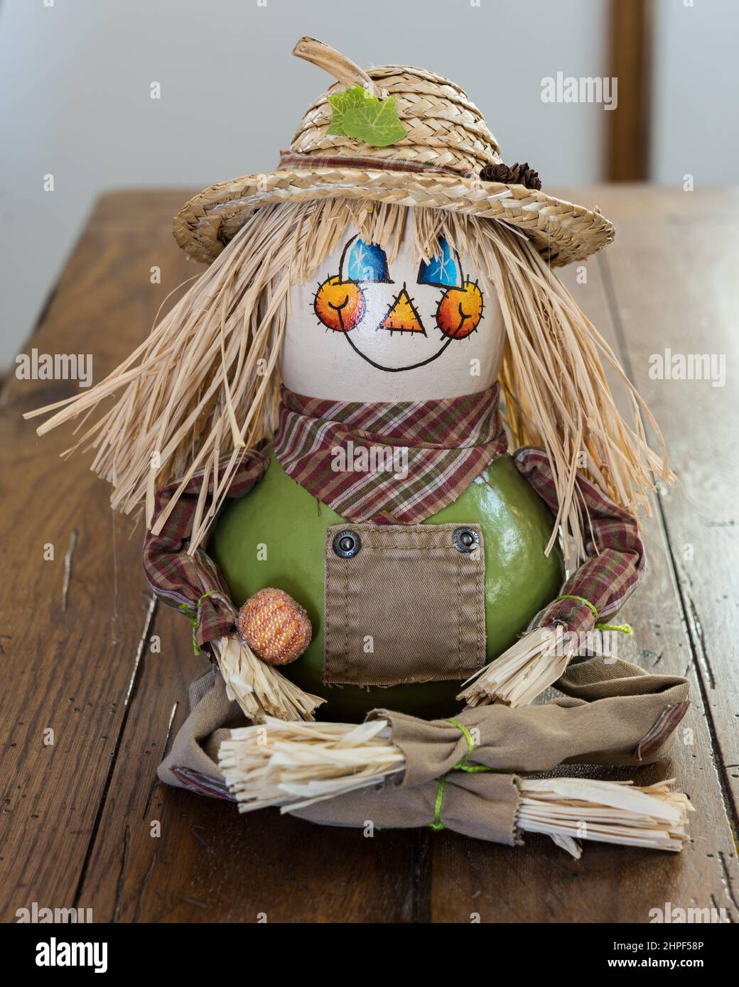 A handmade painted gourd in the shape of a scarecrow for the ...