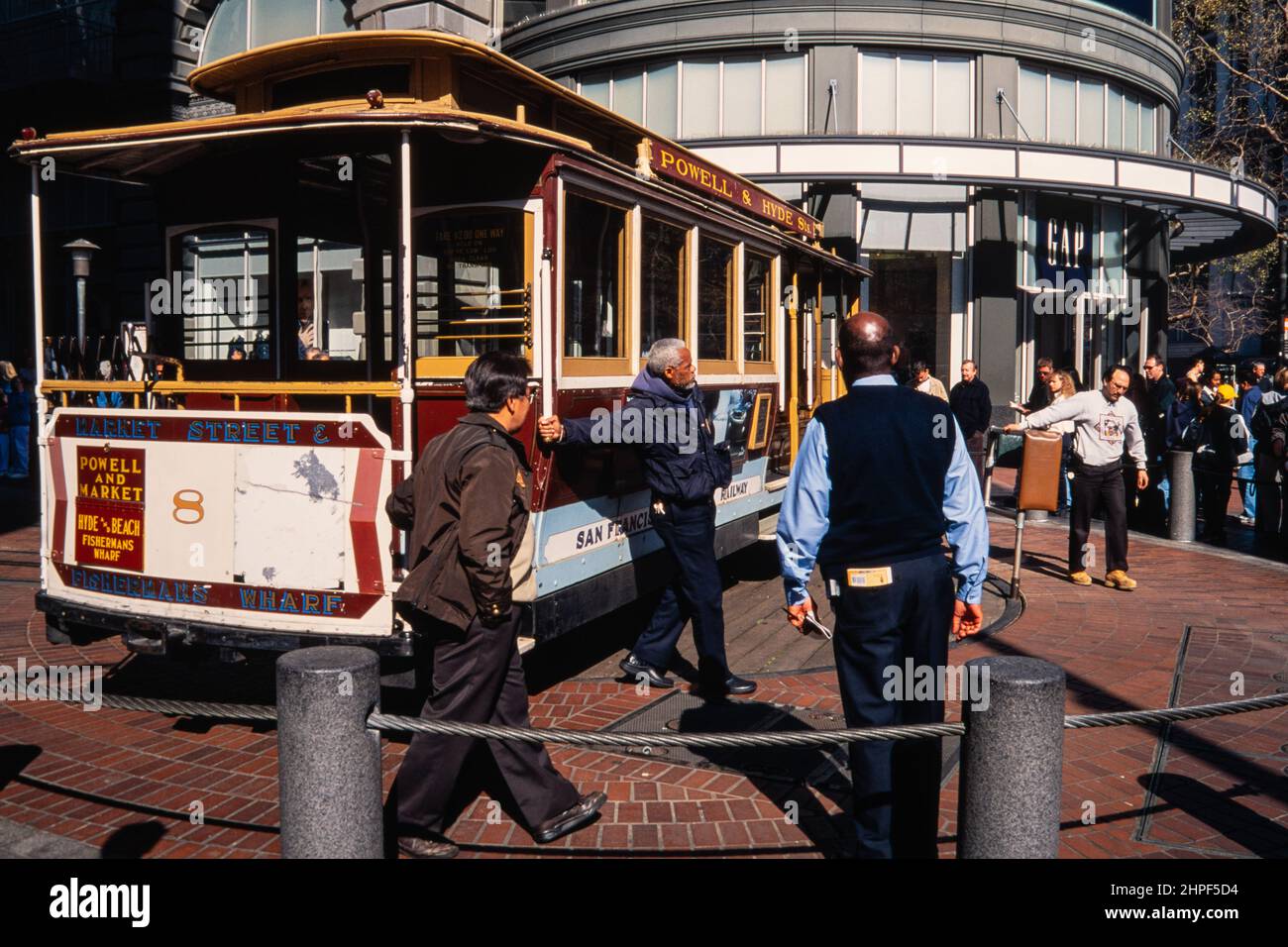 A classic cable car being turned on a turntable to reverse directions ...