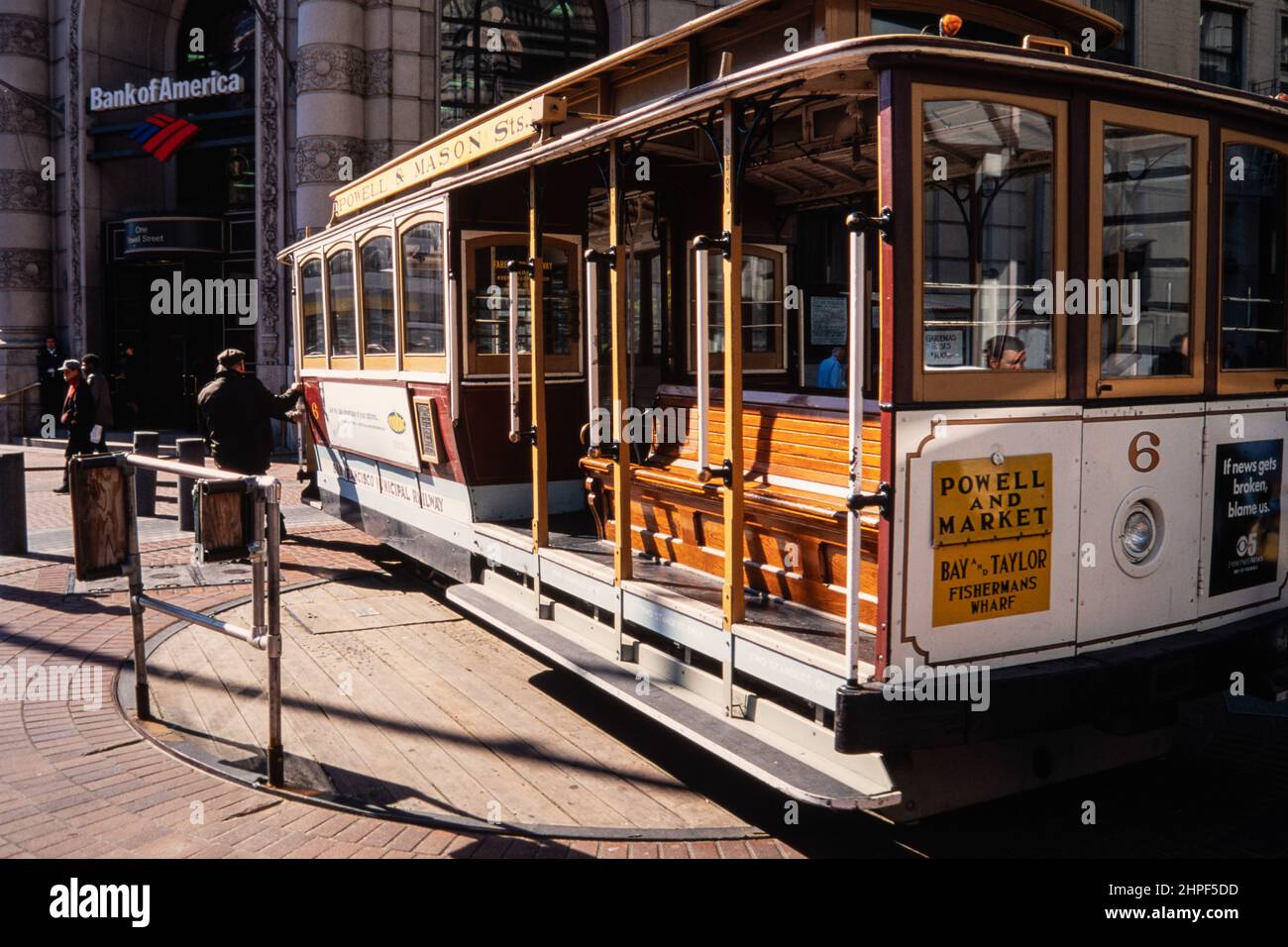 A classic cable car being turned on a turntable to reverse directions ...