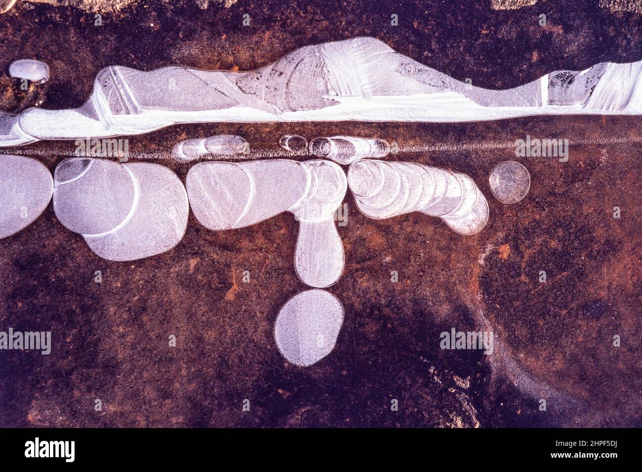 Frozen patterns in ice on sandstone in winter in Arches National Park ...
