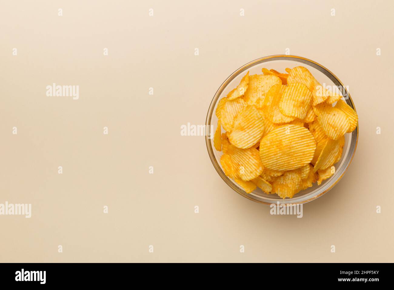 Potato chips on bowl isolated on colored background. Delicious crispy ...