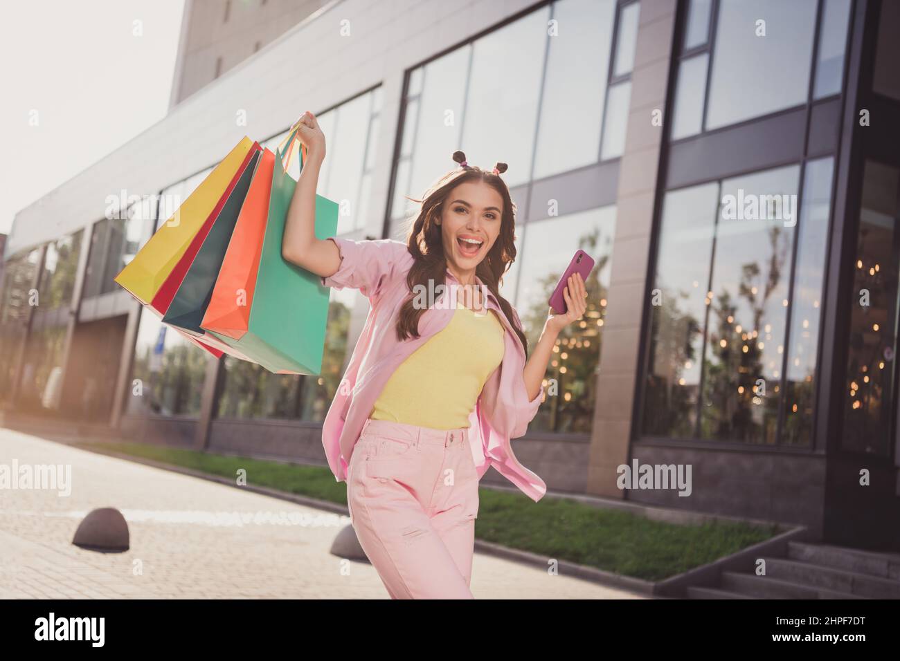Portrait of beautiful cheerful wavy-haired girl buying things using ...