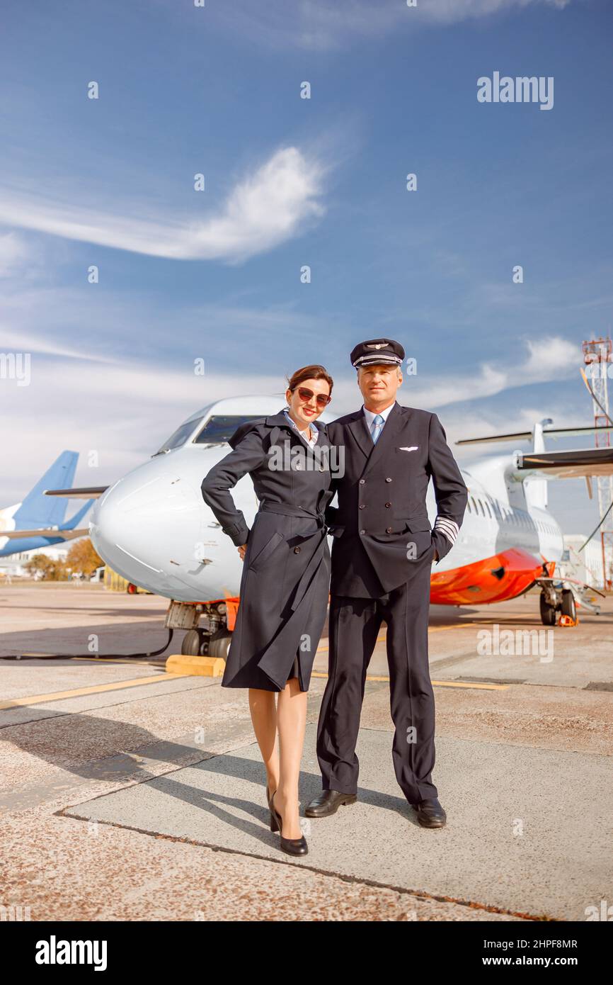 Airplane pilot and stewardess standing outdoors at airport Stock Photo ...