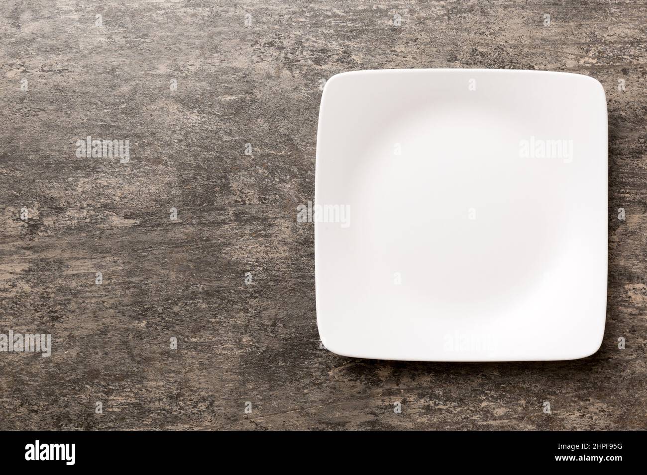 Top view of empty square plate on cement background. Empty space for ...