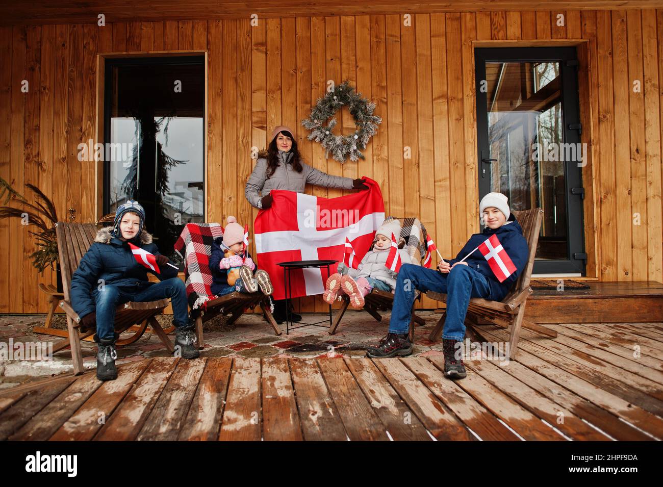 Family with Denmark flags near they wooden house. Travel to ...